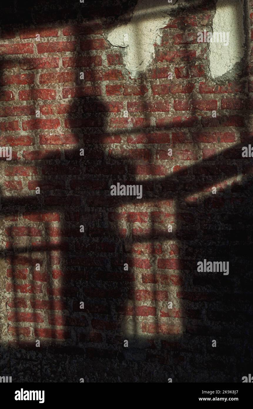 Man in shadow on a red brick wall Stock Photo - Alamy