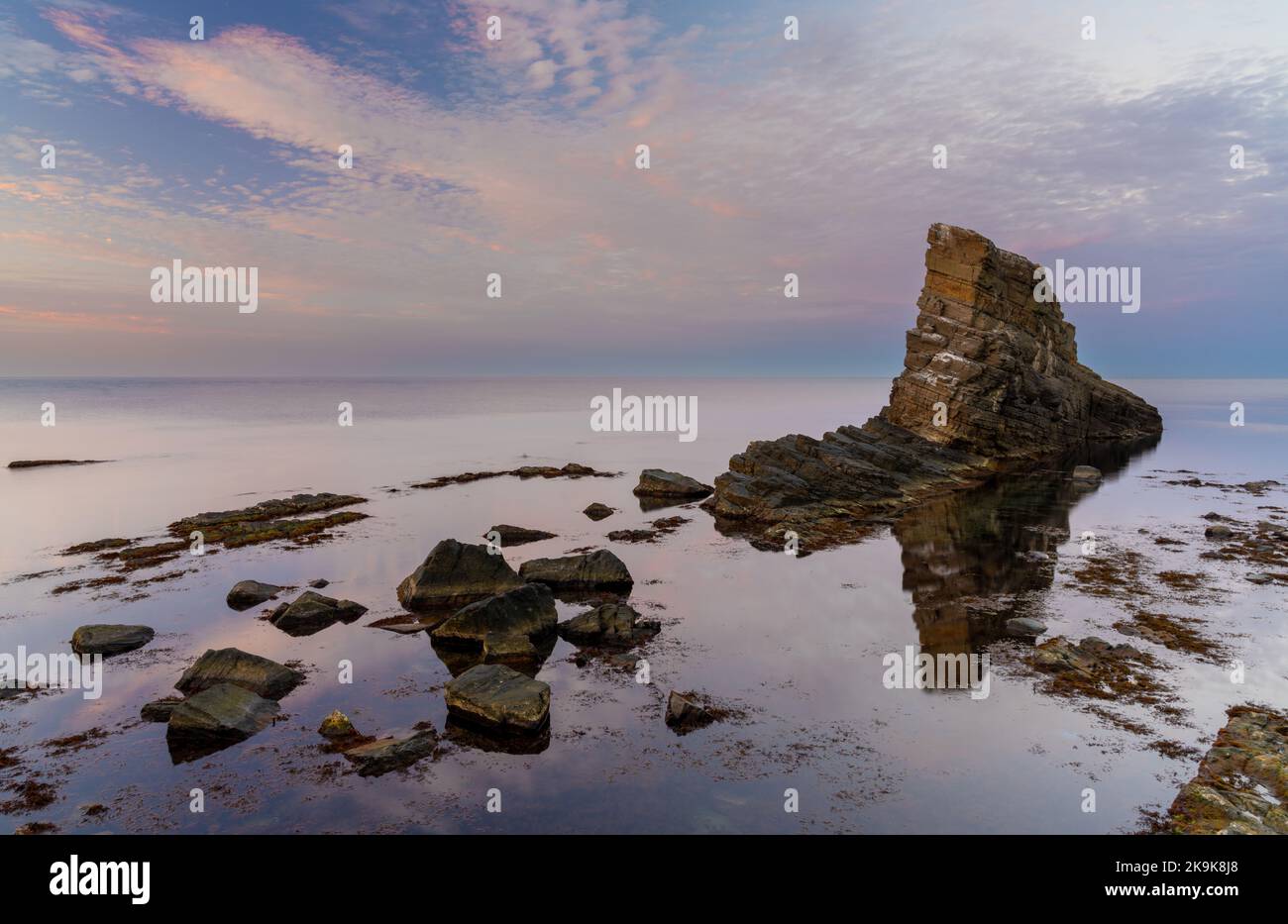 Colorful sunset over the Black Sea coast of Bulgaria with a sea stack ...