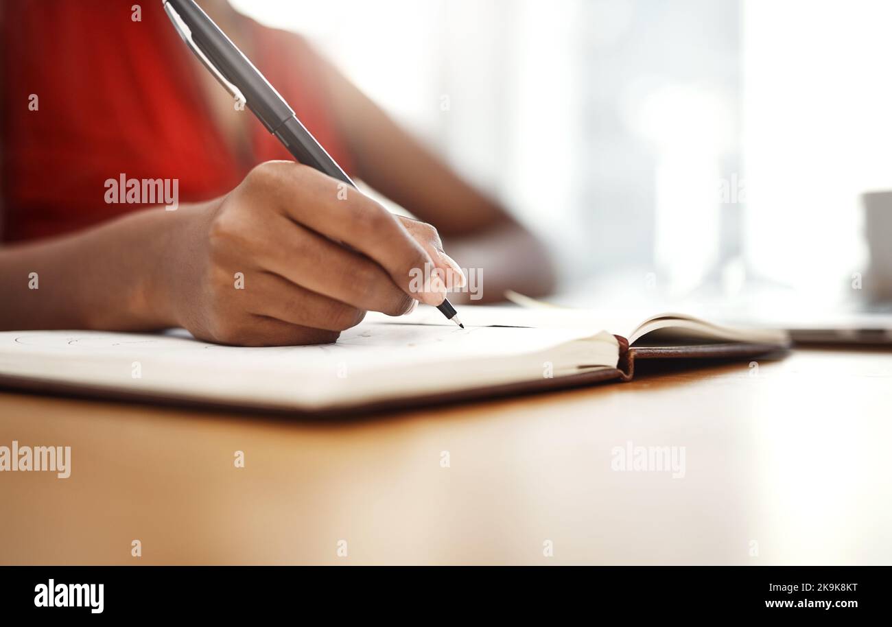 Writing down her agenda for the day. an unrecognizable businesswoman ...
