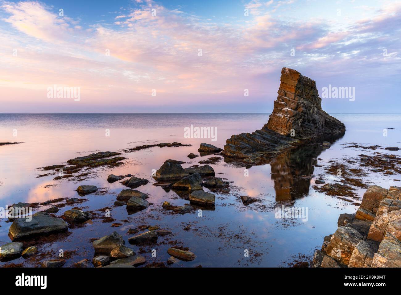 Colorful sunset over the Black Sea coast of Bulgaria with a sea stack ...