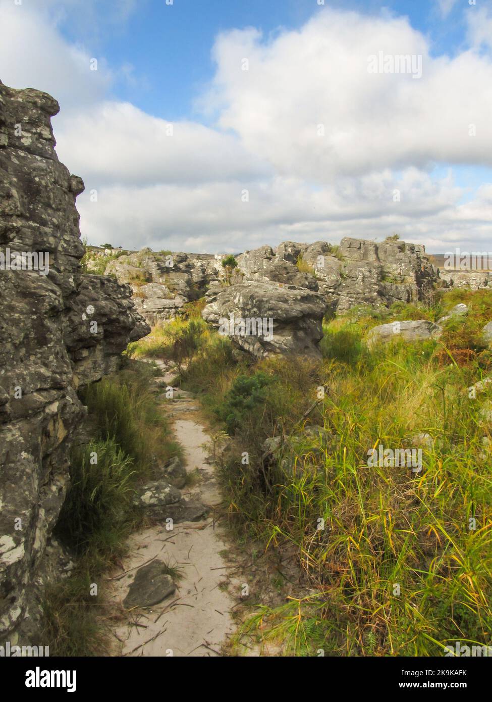 Hiking trail going through a maze of we Grey and Weathered boulders ...