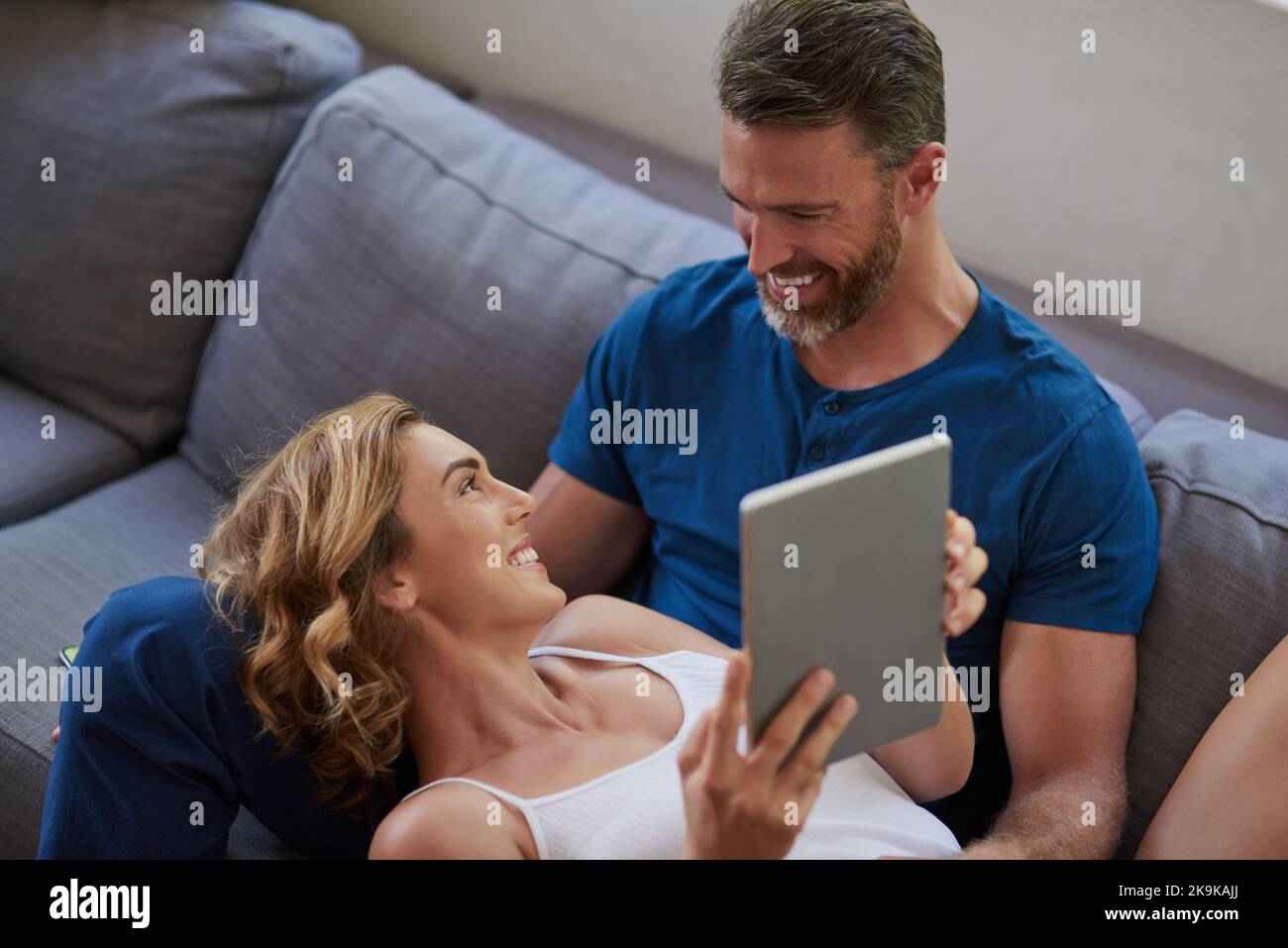 Lets stay in and stream movies all day. a happy middle aged couple ...