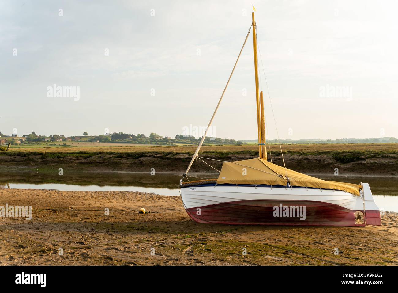 A boat called Trinity at rest in Blakeney, Norfolk, on a sunny evening ...