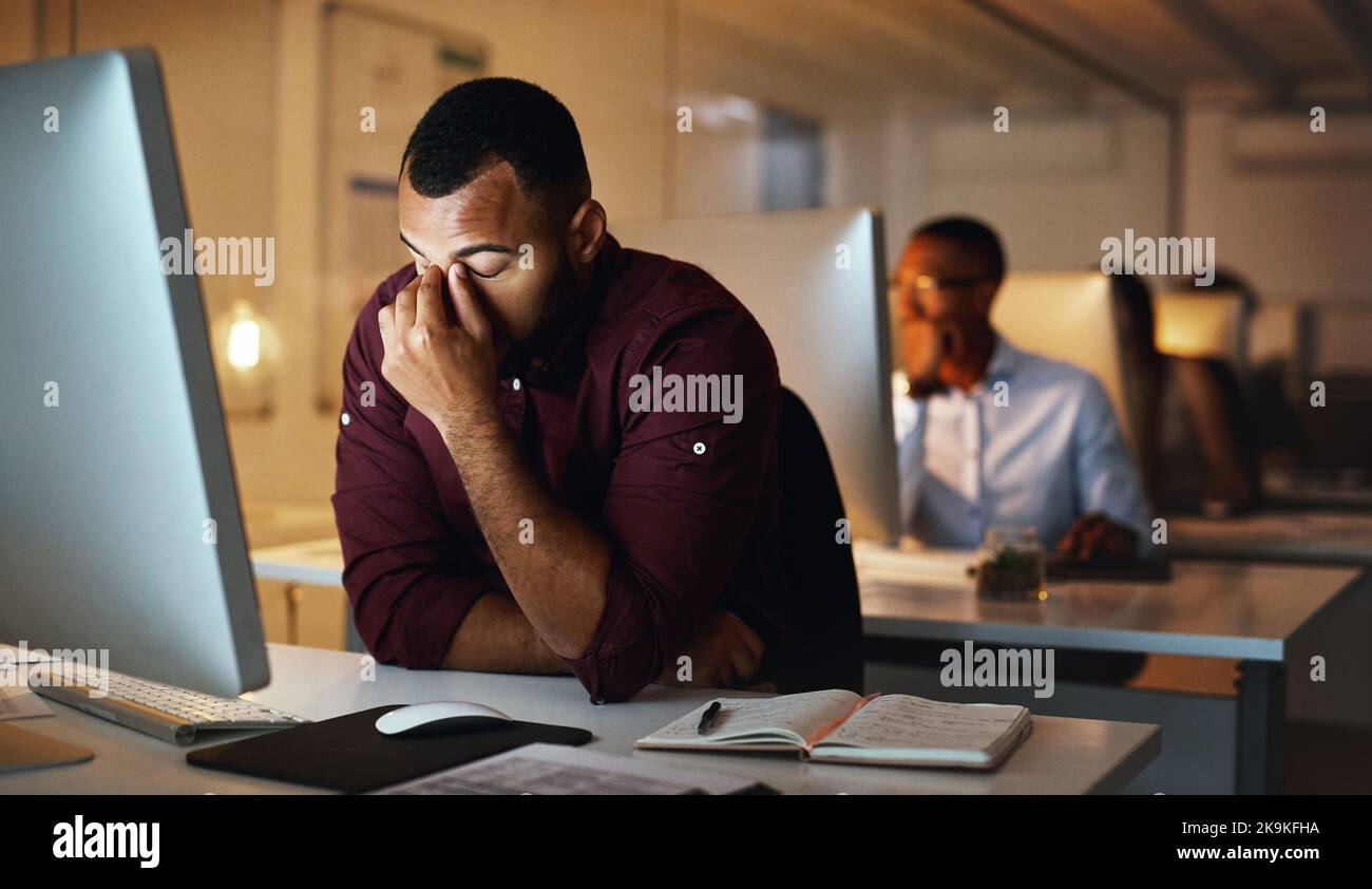 Overtime is starting to kill me now. a young businessman looking ...