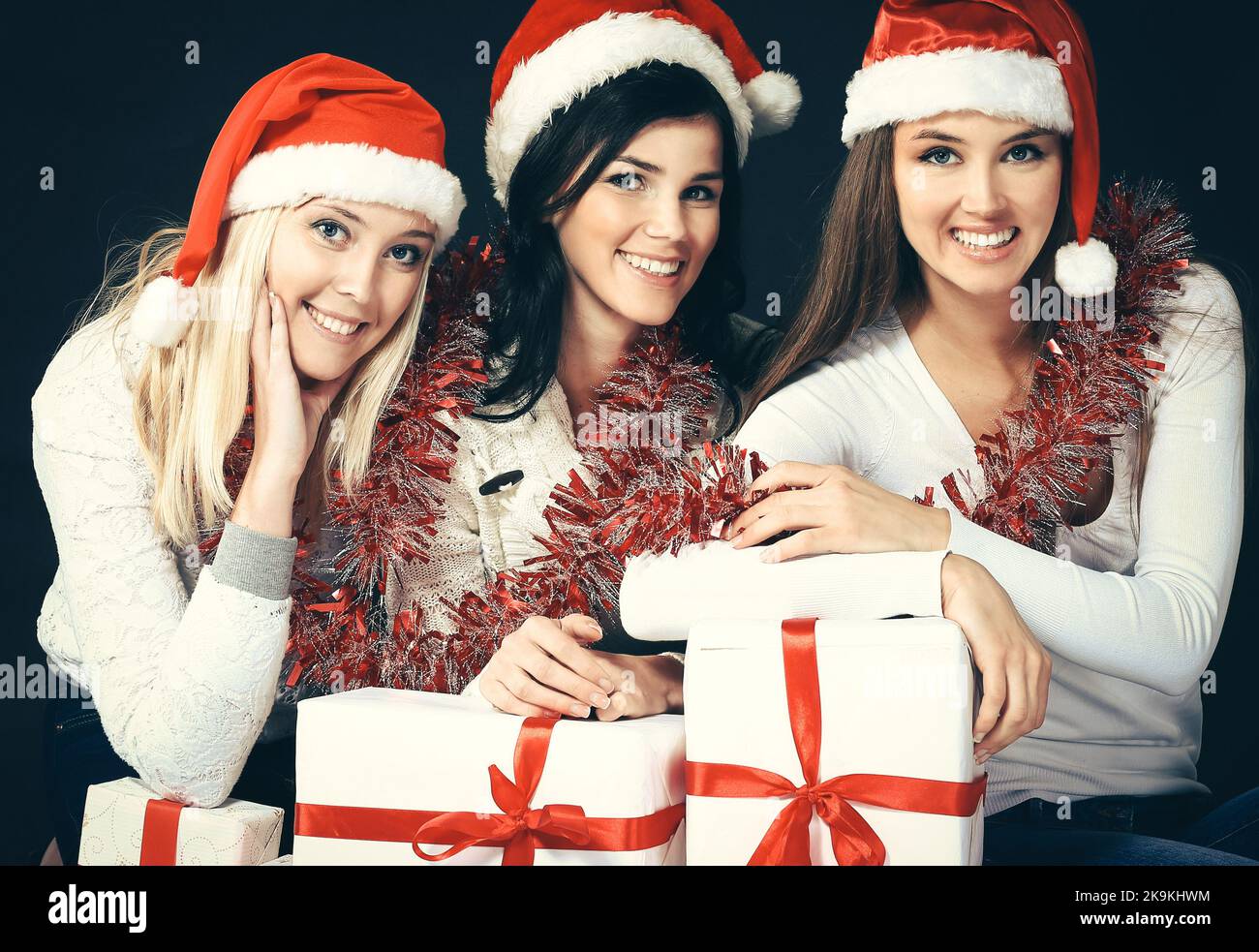 group of happy women in costumes of Santa Claus and Christmas shopping ...