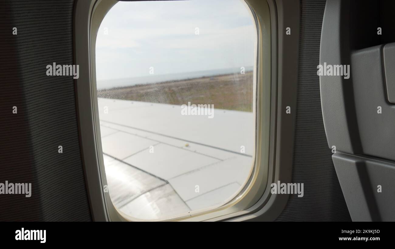 Wing of an airplane, passenger s view. Looking through the window of a ...