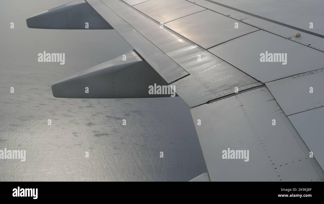 Wing of an airplane, passenger s view. Looking through the window of a ...