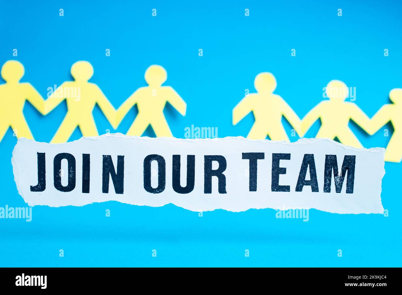 Join our team, written with stamped capital letters on a strip of white ...