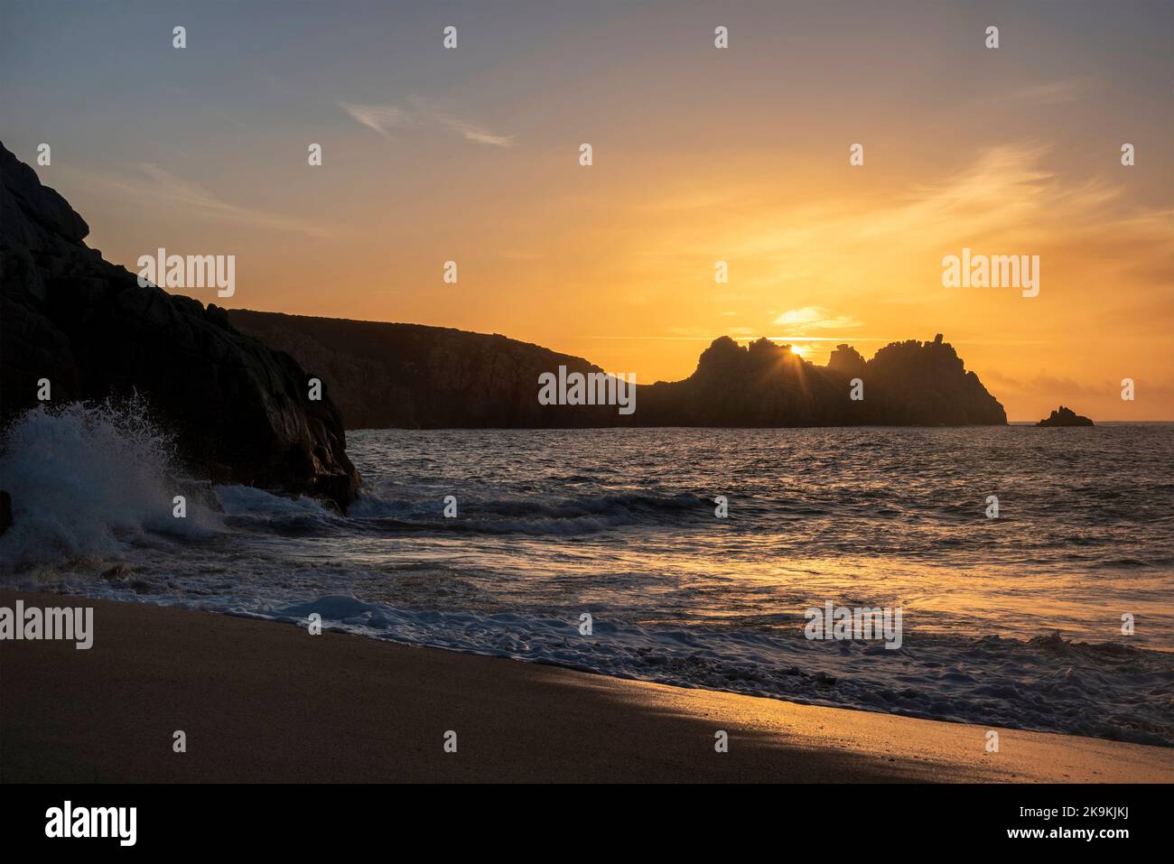 Beautiful sunrise landscape at Porthcurno beach in Cornwall England with stunning colours and ...