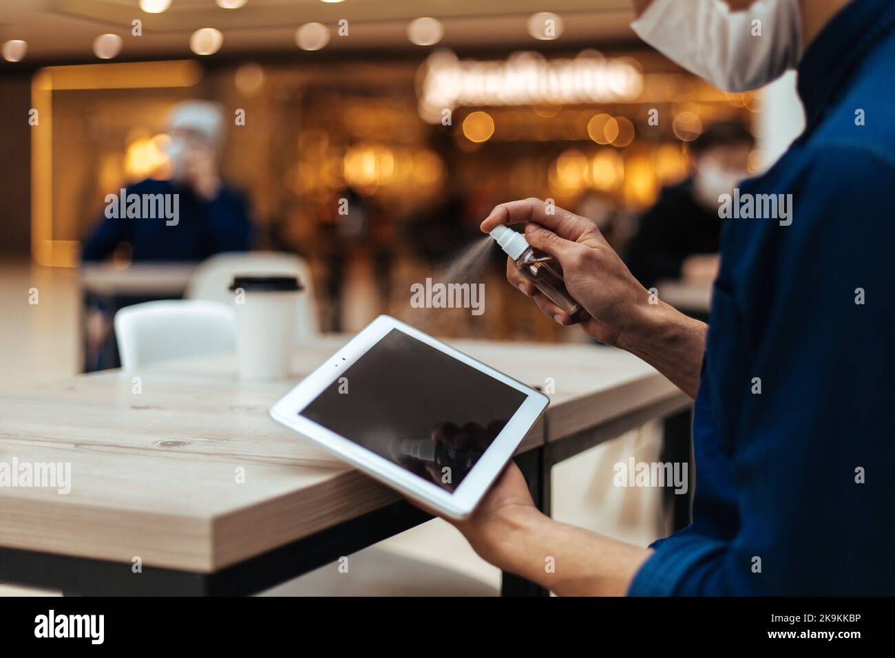 close up . cafe visitor spraying antiseptic on his digital tablet Stock ...