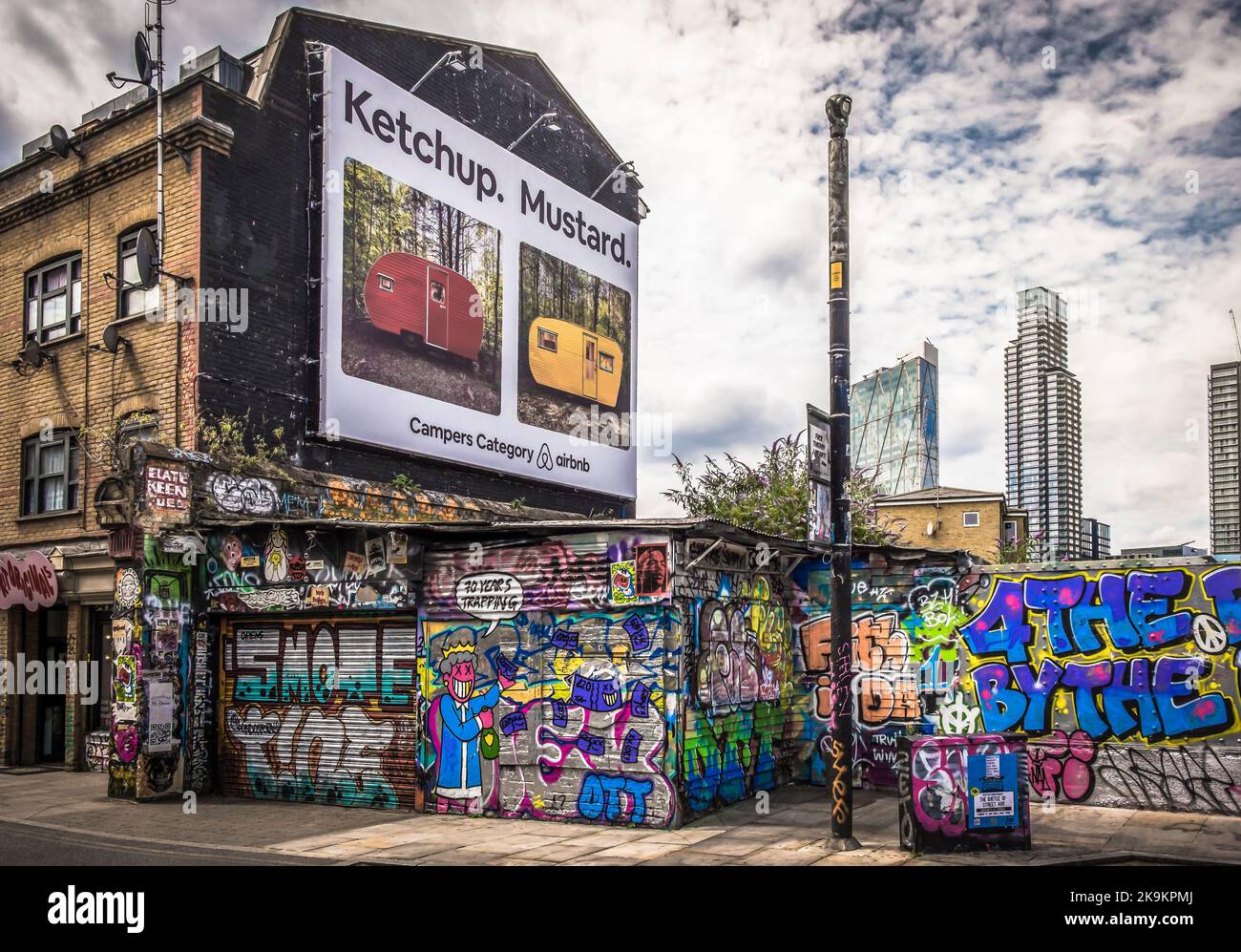 London, UK, July 2022, view of a billboard advertising and murals in ...