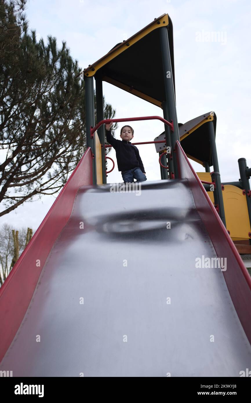 kid on the top of a slide in a playground Stock Photo - Alamy