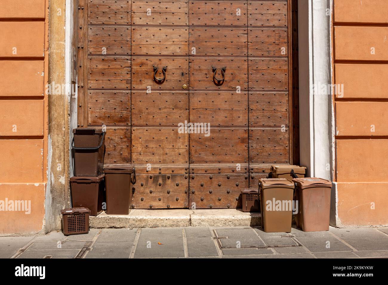 Bins with biological waste on the sidewalk in front of a historic door ...