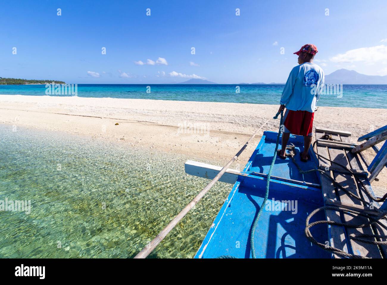 A Filipino man looking out of a tradition boat's prow as it gets ready ...