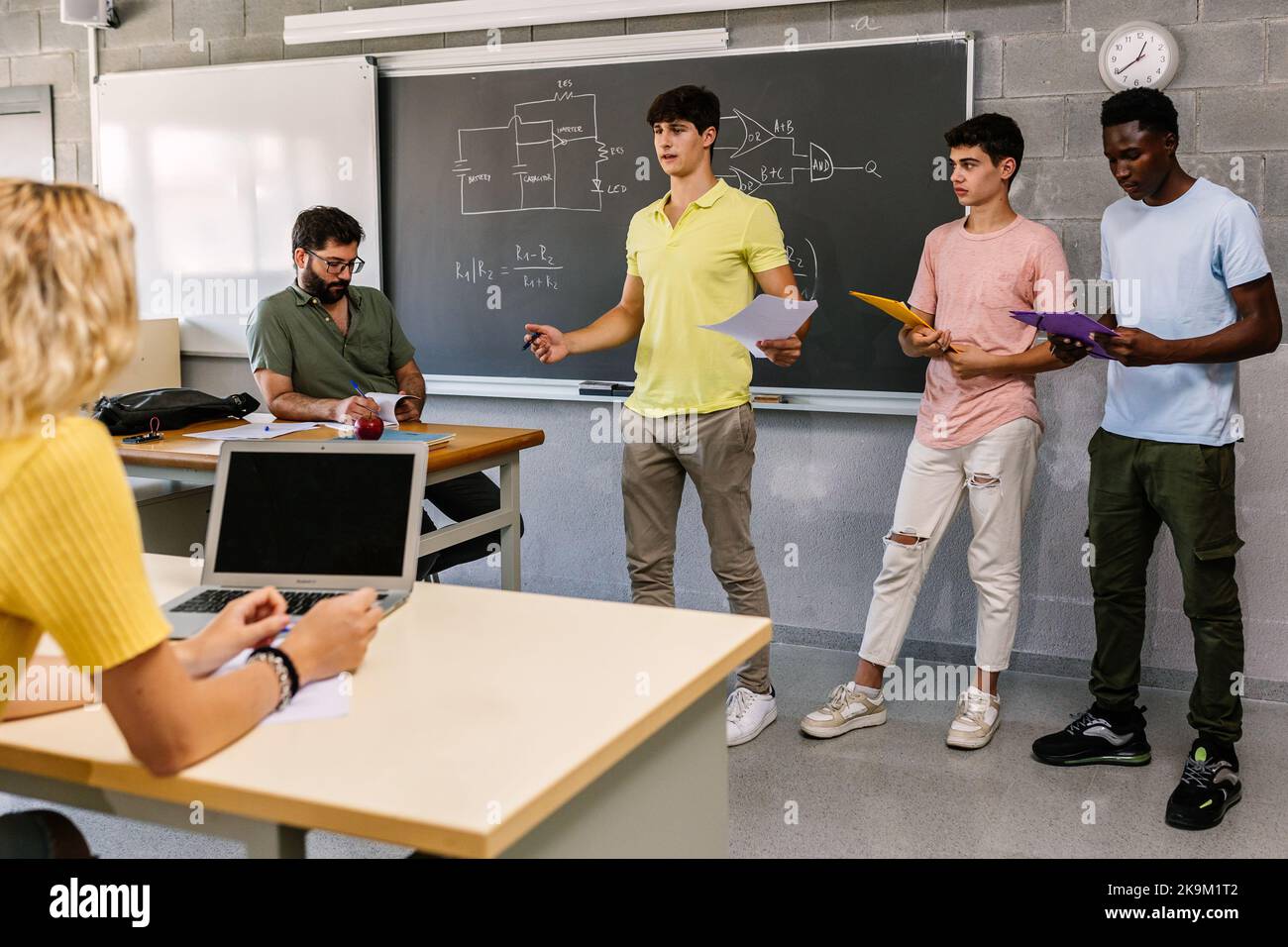 Diverse group of three young male students teaching personal project at ... Diverse group of three young male students teaching personal project at ...