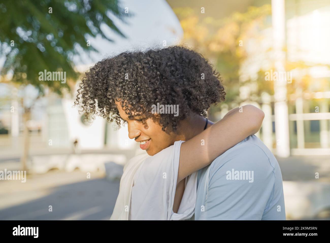 Friendly hug concept, smiling millennial black man and woman cuddling ...