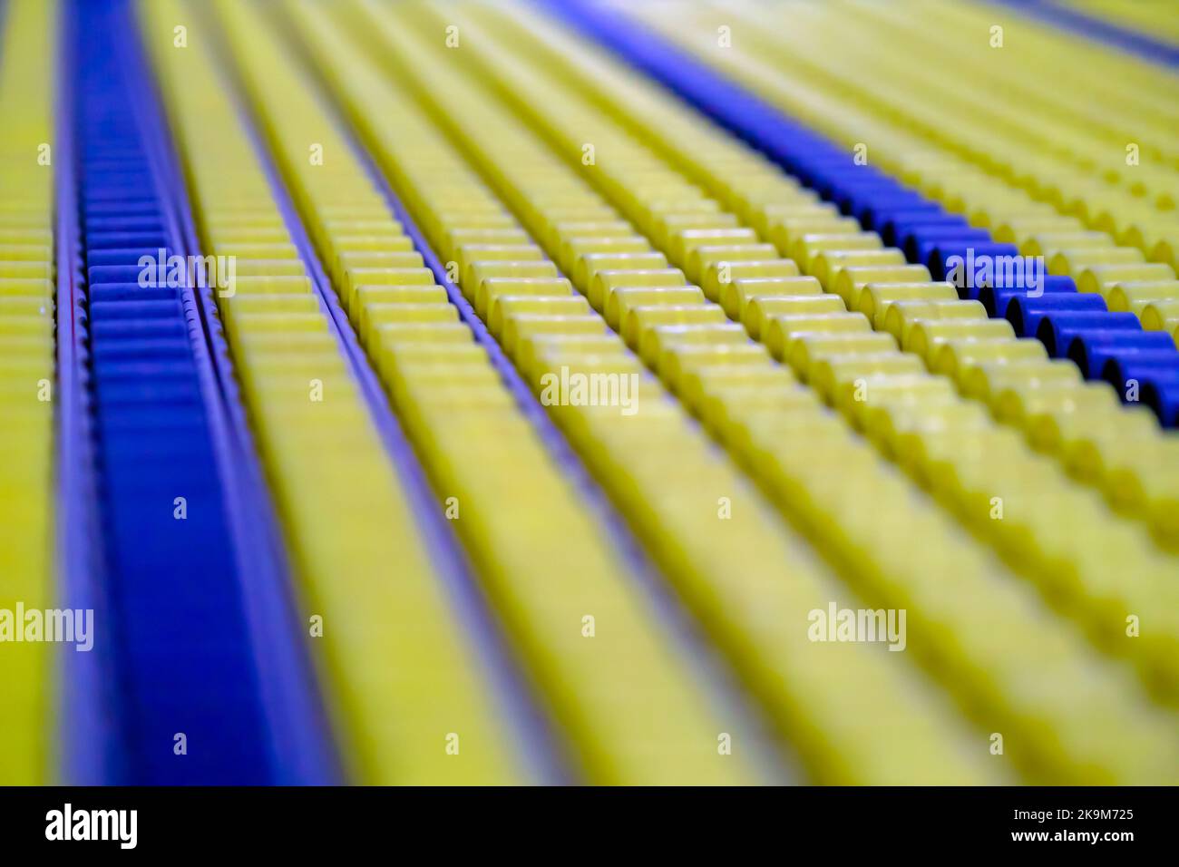 Yellow and blue conveyor rollers Stock Photo - Alamy