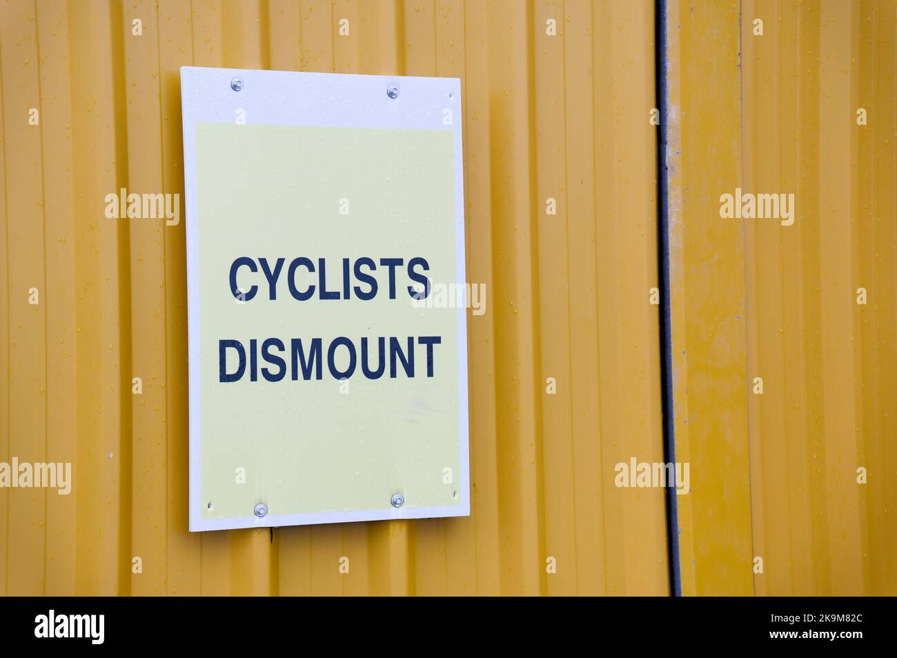 Cyclists dismount sign for safety of pedestrians on shared walk path ...