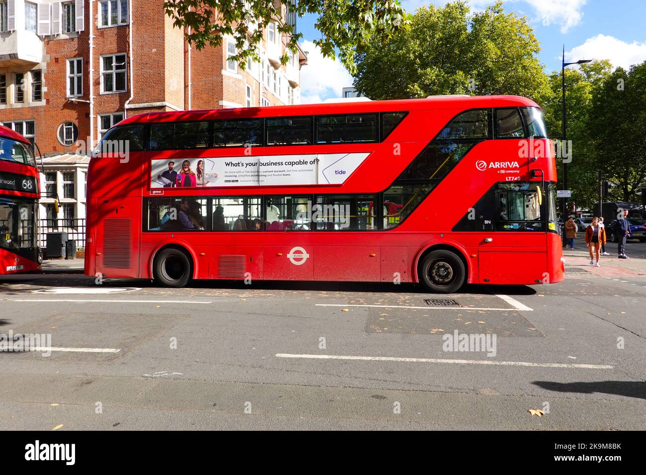 Double-decker buses, with people, pull out of Euston Station and onto ...