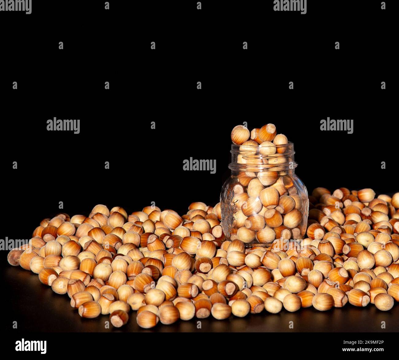Hazelnut in a jar. Lots of hazelnuts. Bank with nuts on a black ...