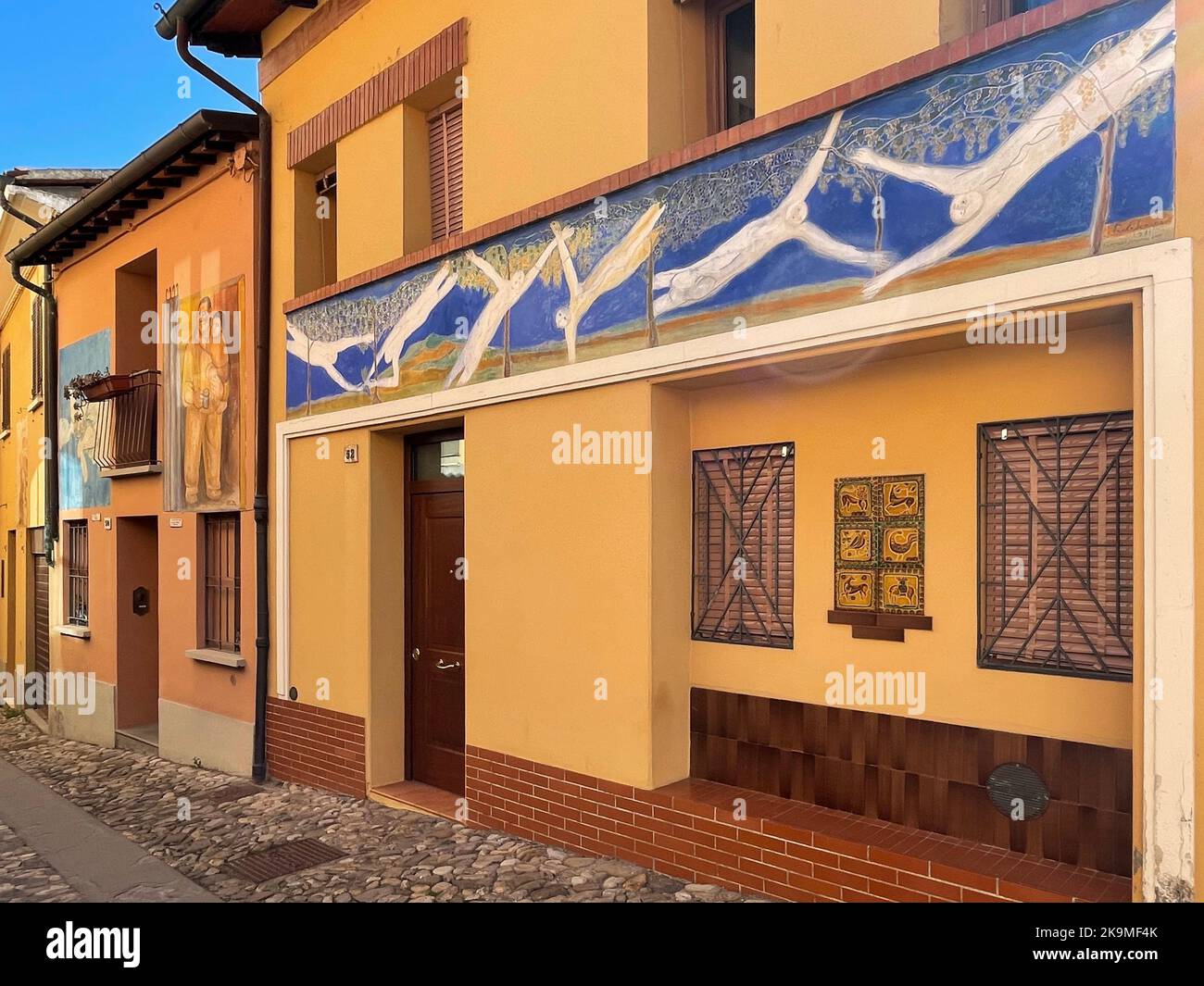 Dozza, Italy. Murals on the facade of historical buildings. "Uomini che ...
