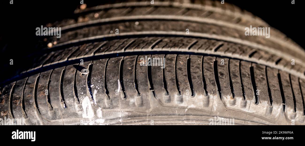 screw protruding from the tread of a tire causing a flat Stock Photo ...