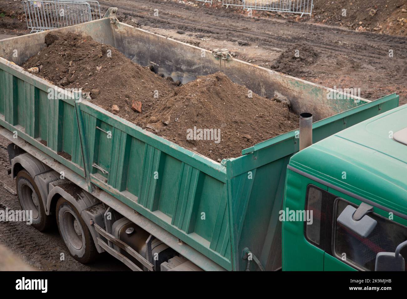 A Dump truck is moving loaded with ground soil on a construction site ...