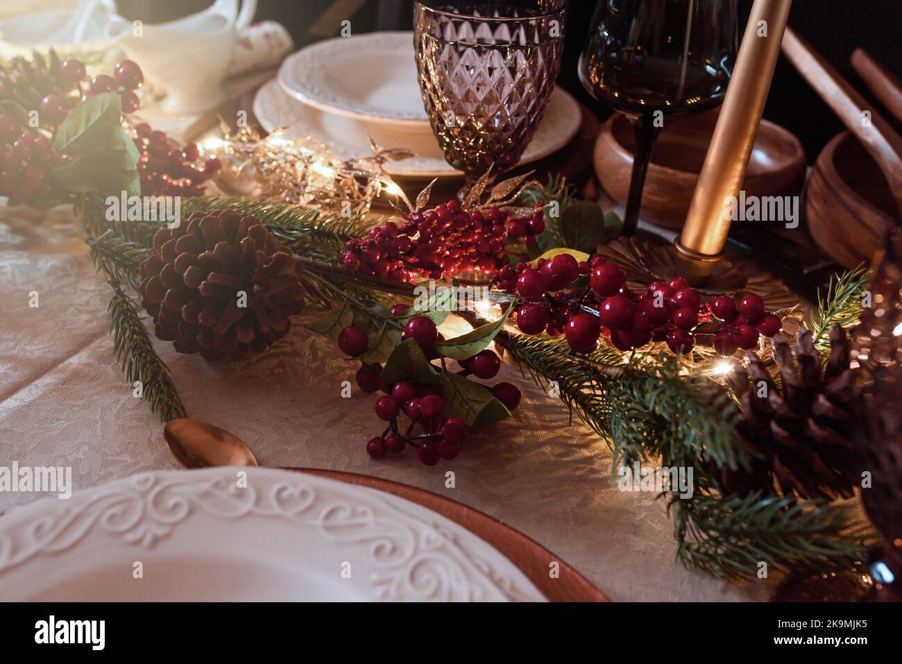 Table prepared for Christmas lunch. Plates and garlands Stock Photo - Alamy