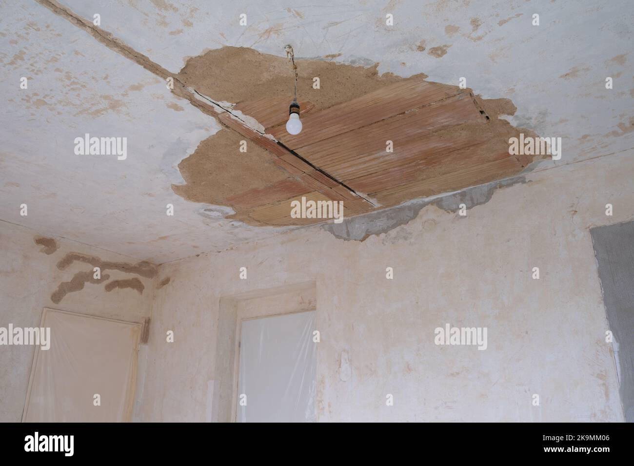 Interior reconstruction off Ruined old ceiling and hanging eco led lamp on. Fixing Repair Aged ...