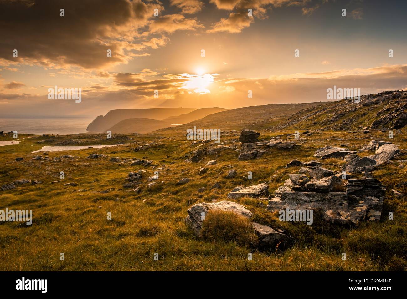 Midnight sun rising over Knivskjellodden, a trail in the tundra towards ...