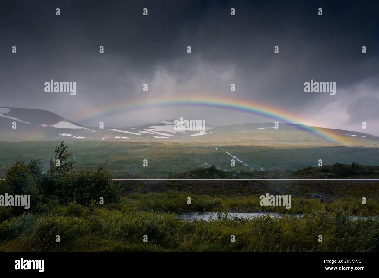 Amazing rainbow in cloudy sky over the tundra landscape on the Arctic ...