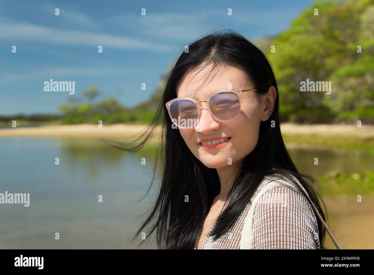 A happy chinese woman posing with a nature landscape background in New ...