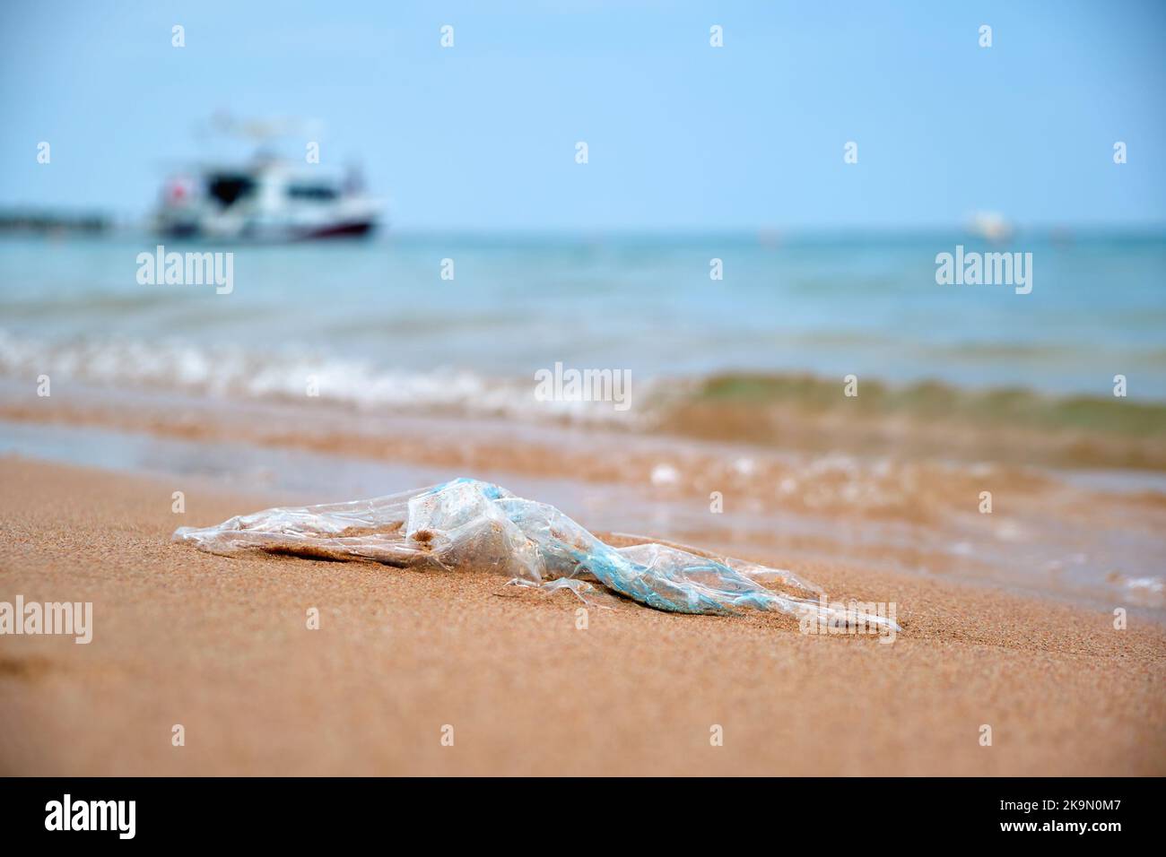 Left behind plastic bag garbage on sandy beach. Empty used dirty litter ...