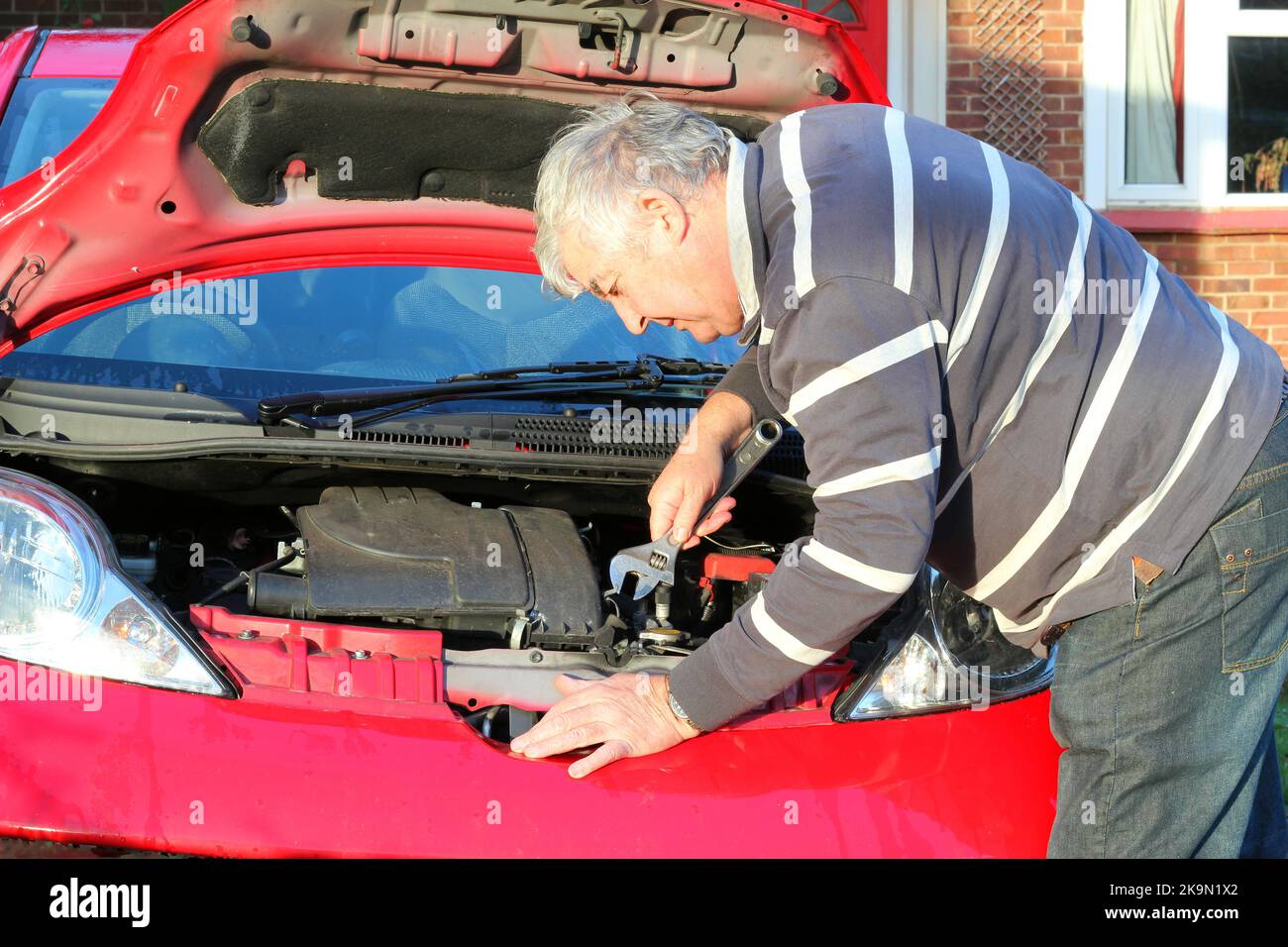 Mechanic working a car. Using spanner on the engine Stock Photo - Alamy