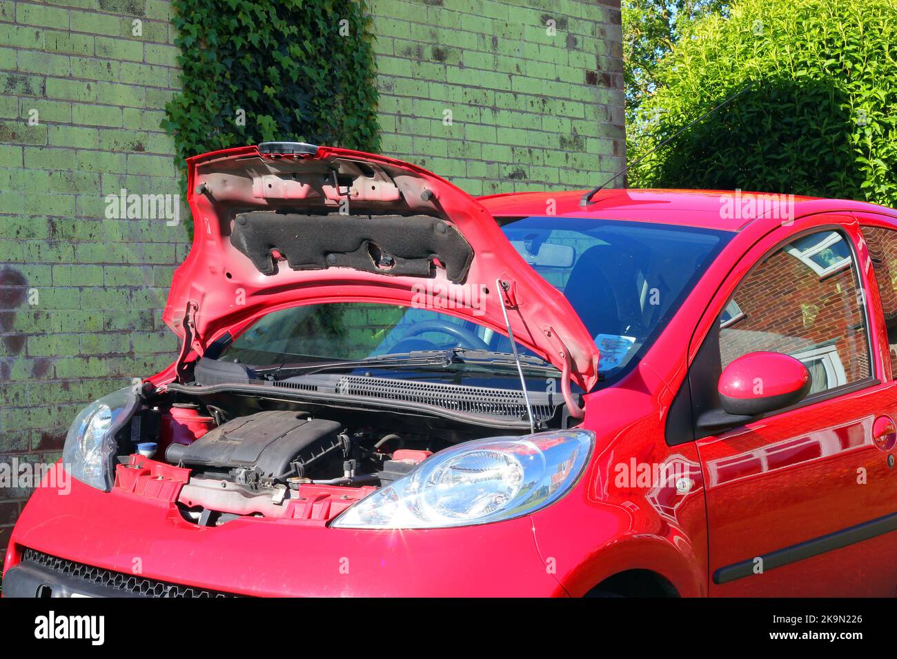 Small car with hood or bonnet open revealing engine Stock Photo - Alamy