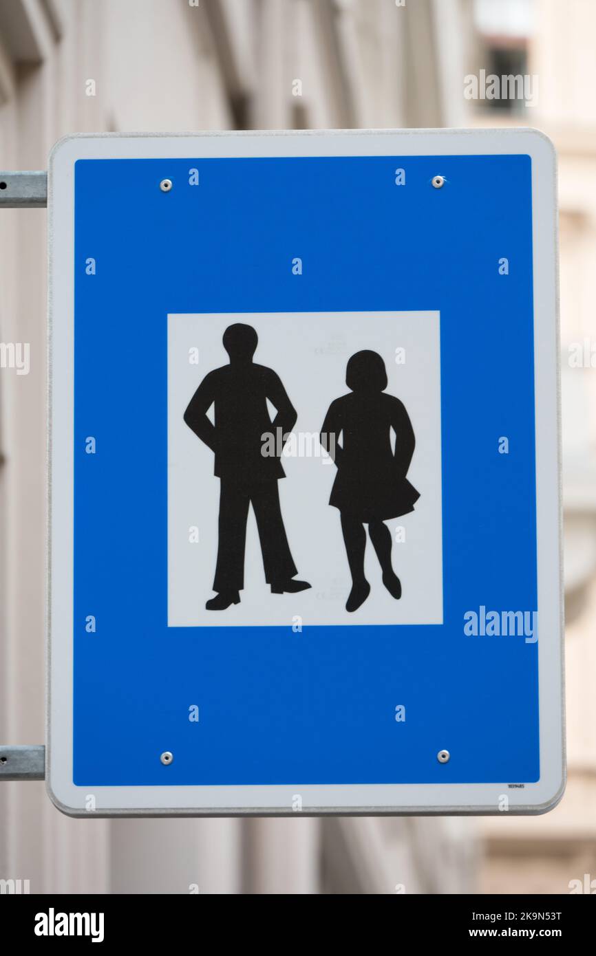 Close-up of a blue billboard traffic sign with a man and a woman as ...