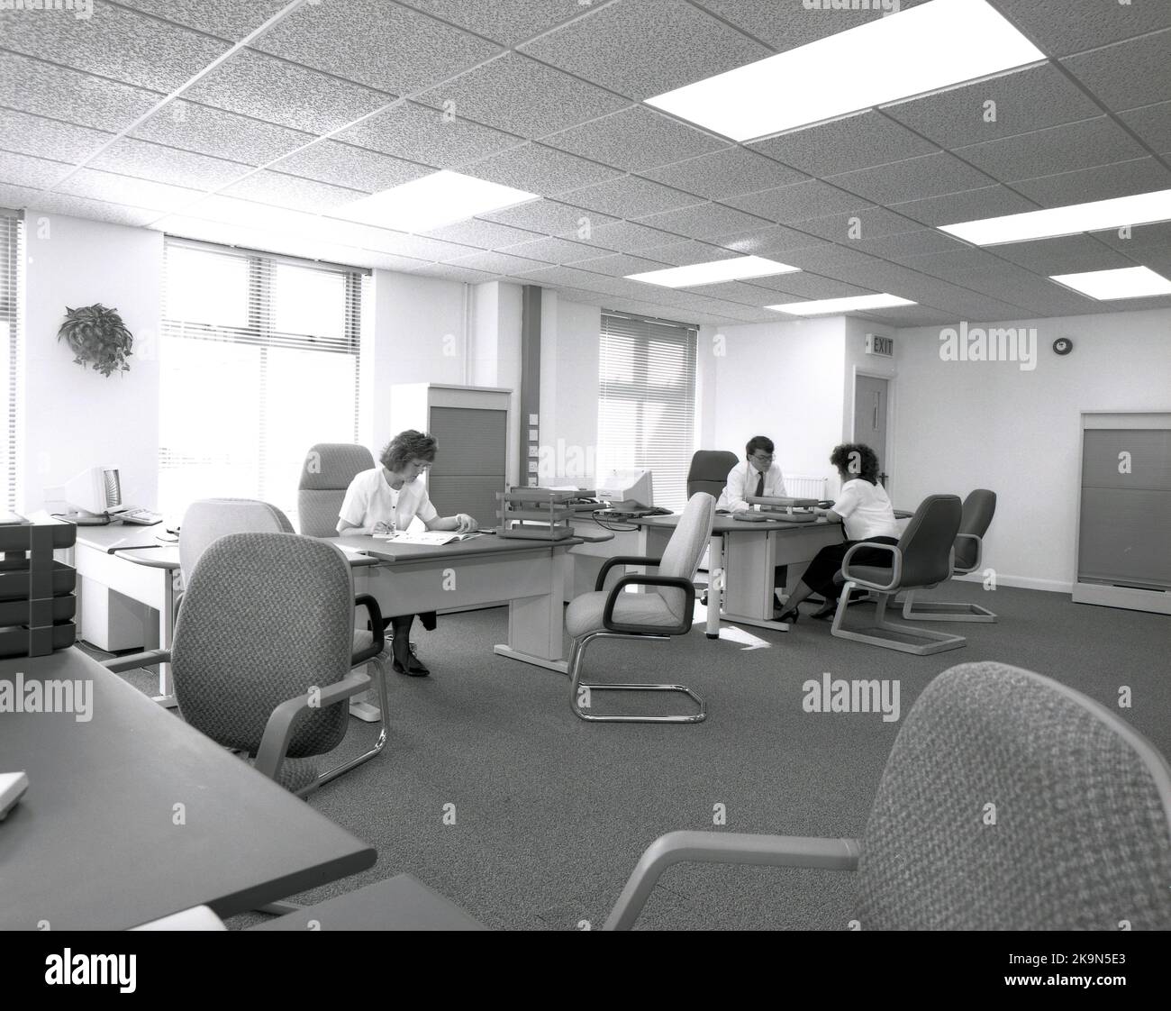 1989, historical, a male and female working at their desks in a ...