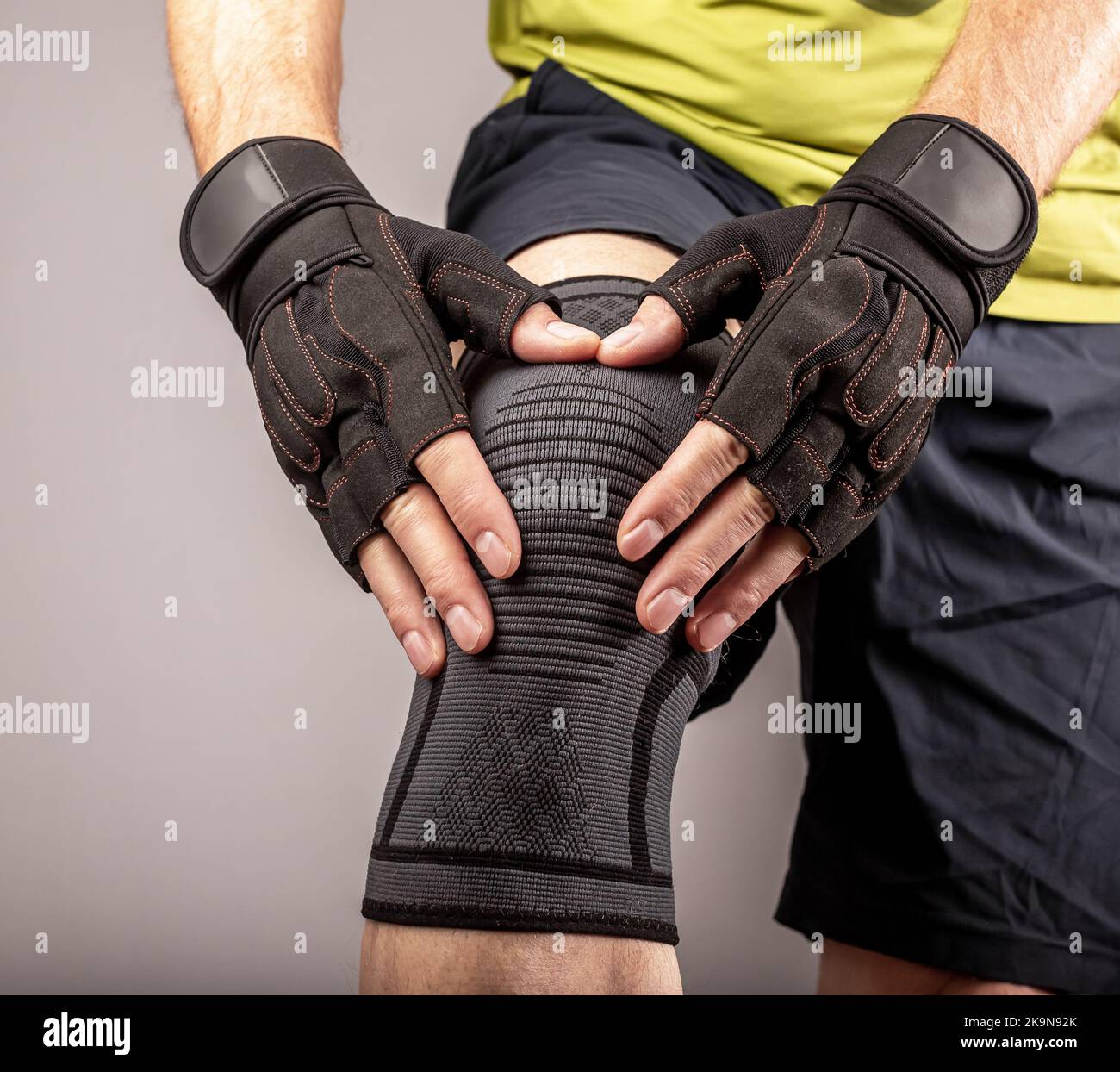 Athlete Bodybuilder Wearing Knee Support Brace Elastic Kneecap Bandage Sleeve For Compression