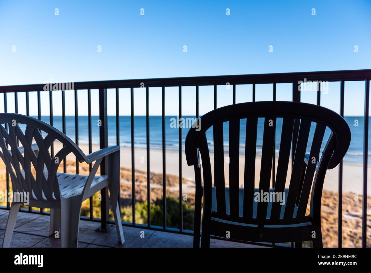 Seascape view through balcony railing with two chairs at Myrtle Beach ...