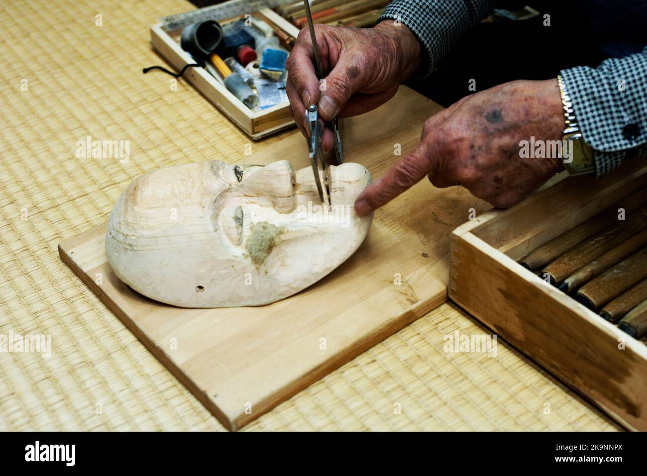 Hizawa Koun measuring a female mask with calipers. The mask has been ...