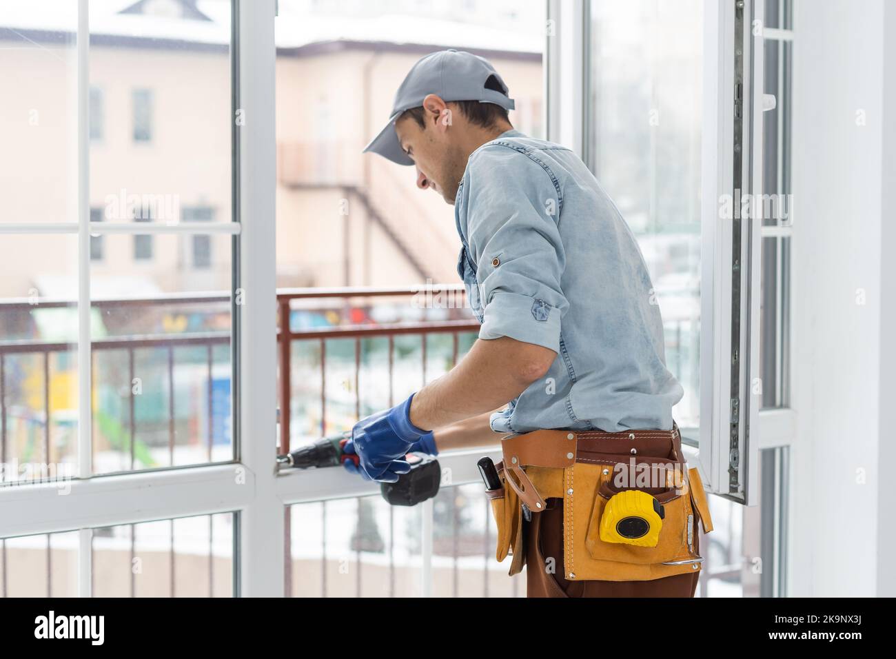 Construction worker installing window in house. Handyman fixing the ...
