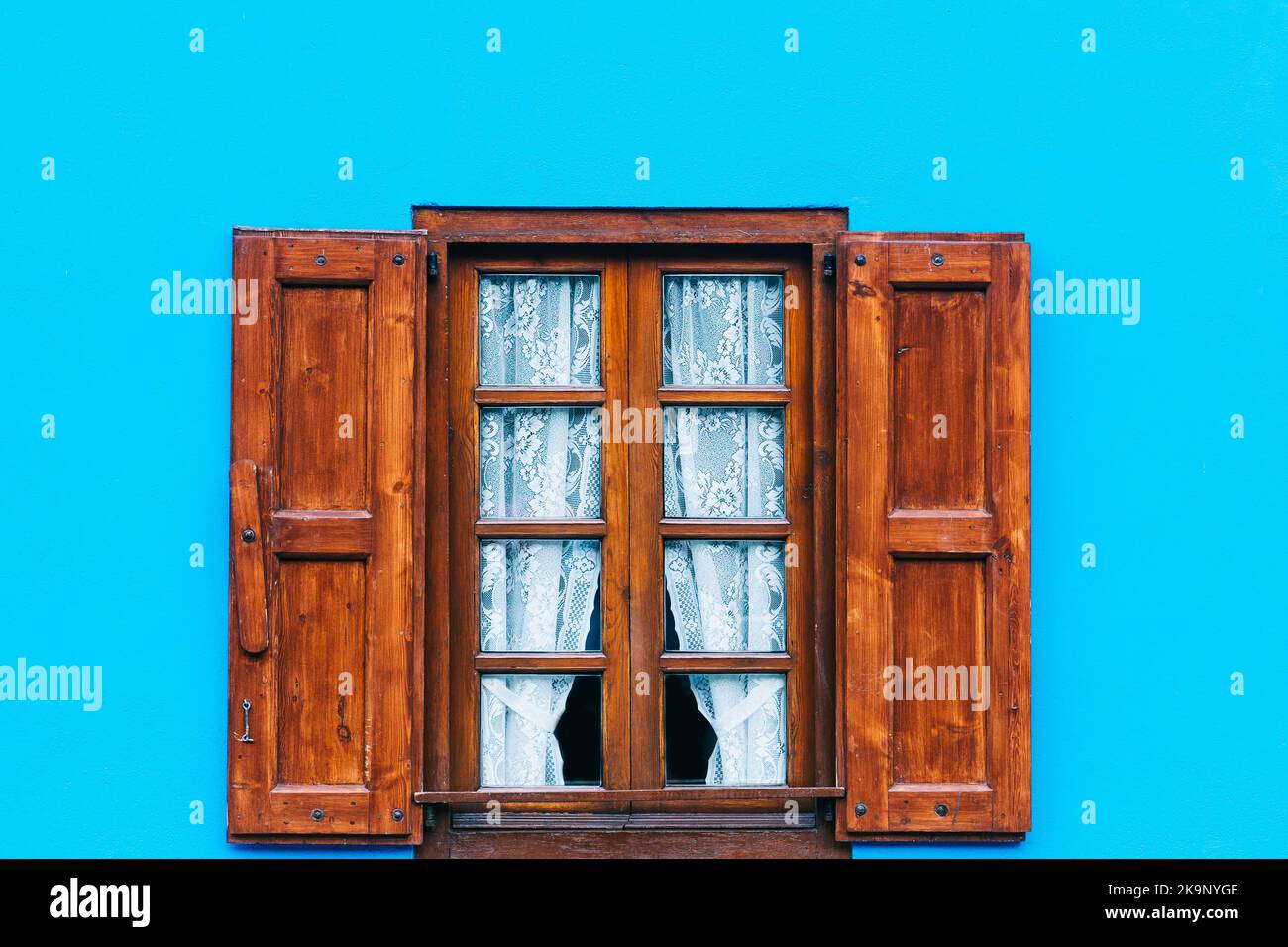 Wooden vintage window on blue house wall background Stock Photo - Alamy