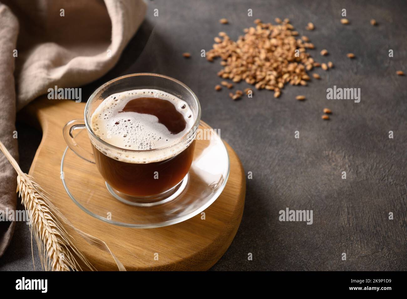 Barley coffee in glass cup, beans and ears of barley on brown ...