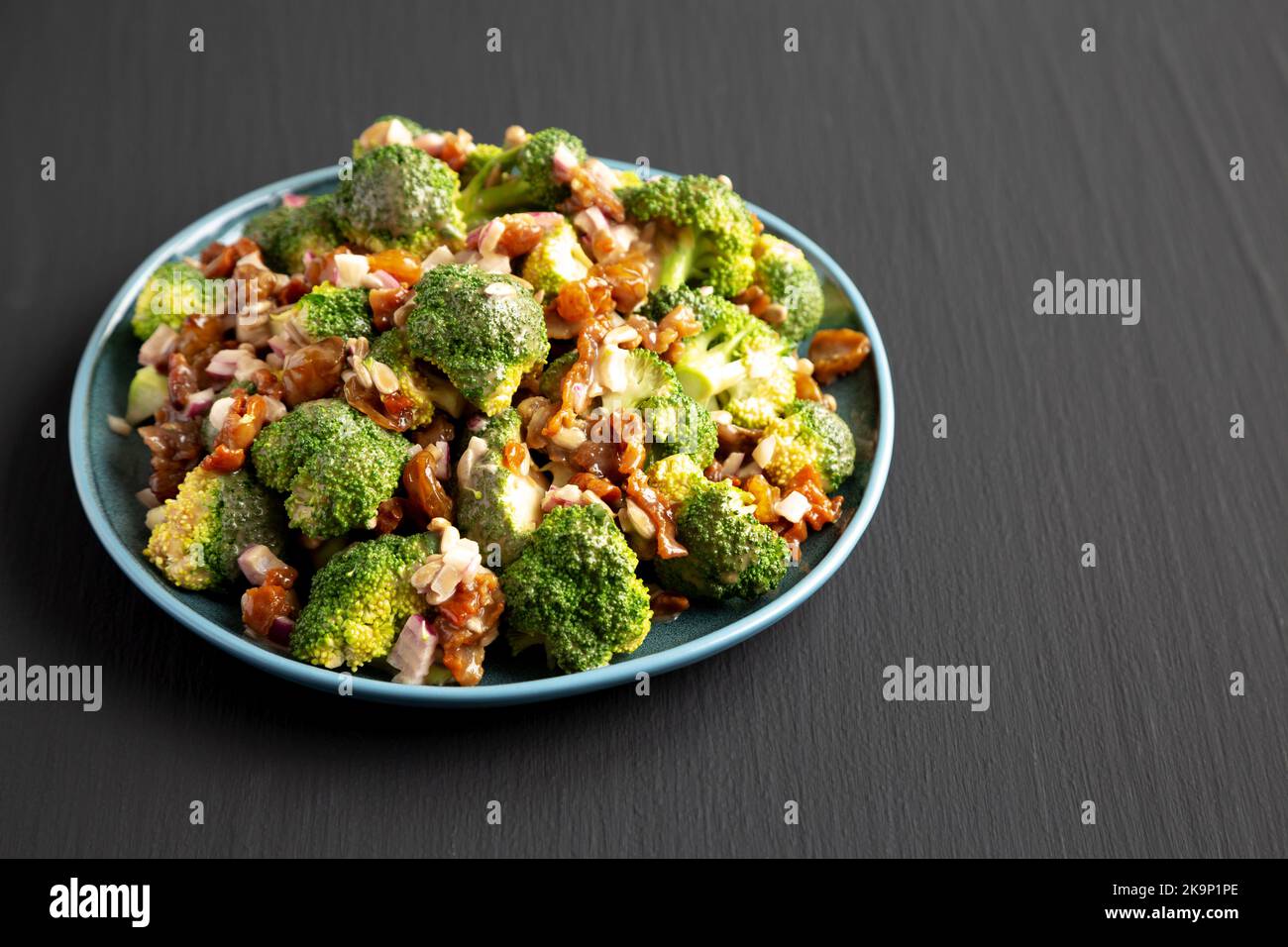 Homemade Broccoli Bacon Salad on a Plate on a black background, side ...
