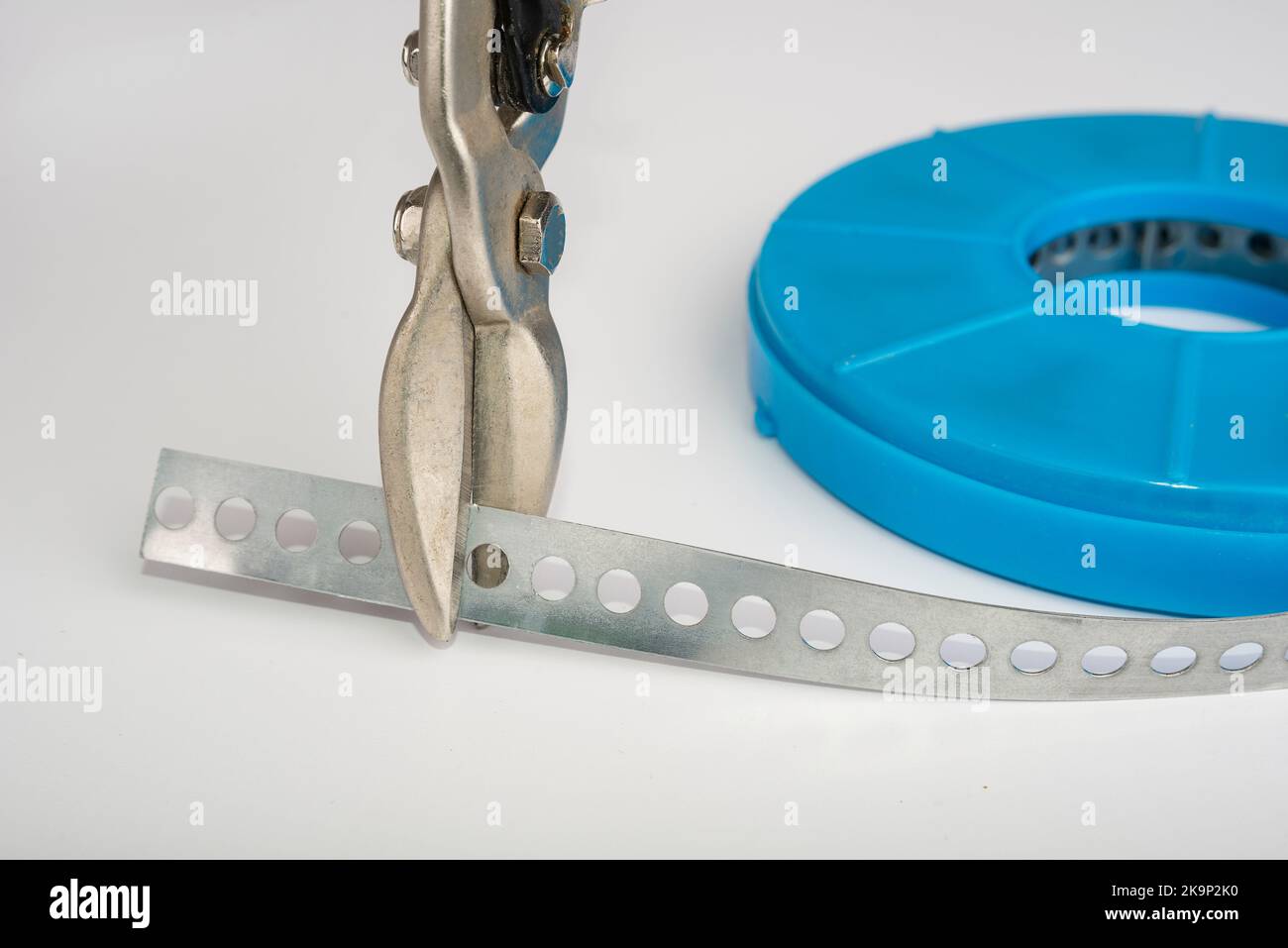 Perforated galvanized steel strip on a white Stock Photo - Alamy