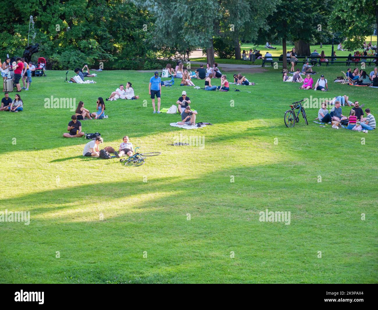 Vienna, Austria - June 2022: People, tourists and locals relaxing and having fun on the green ...