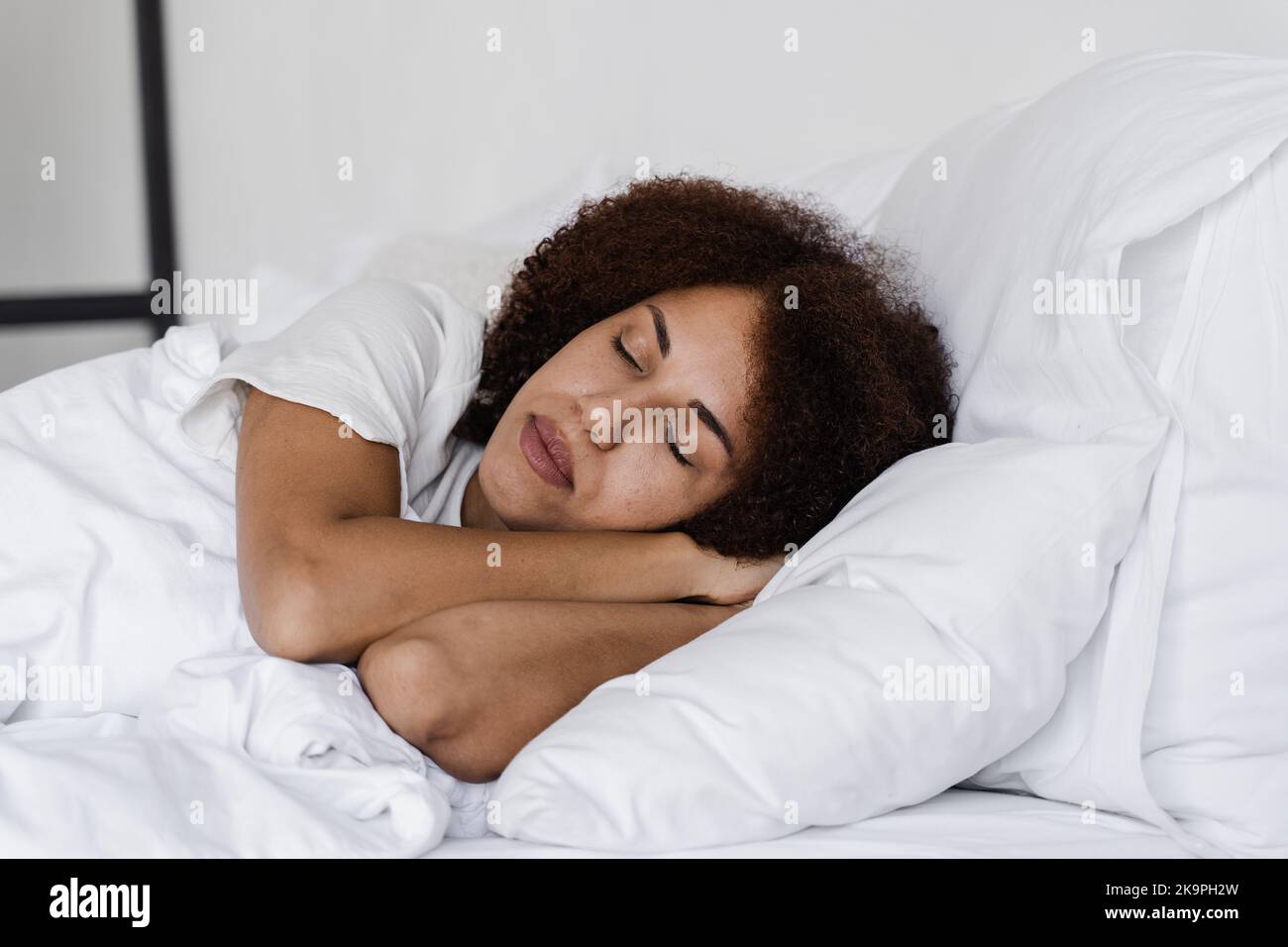Nap day sleep of african girl with closed eyes lay on cozy bed at home ...