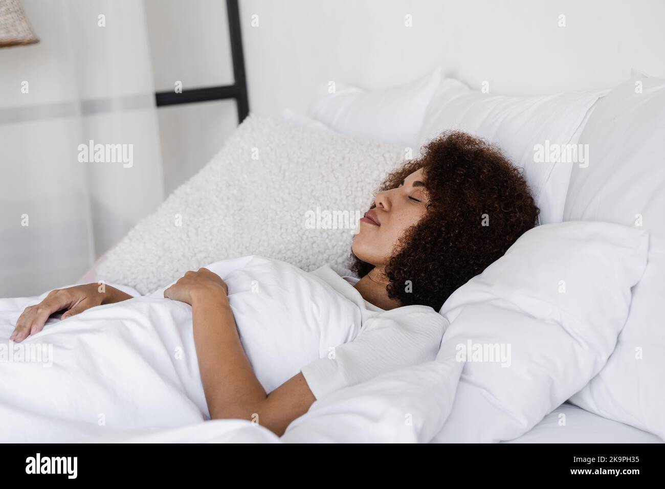 Nap day sleep of african girl with closed eyes lay on cozy bed at home ...