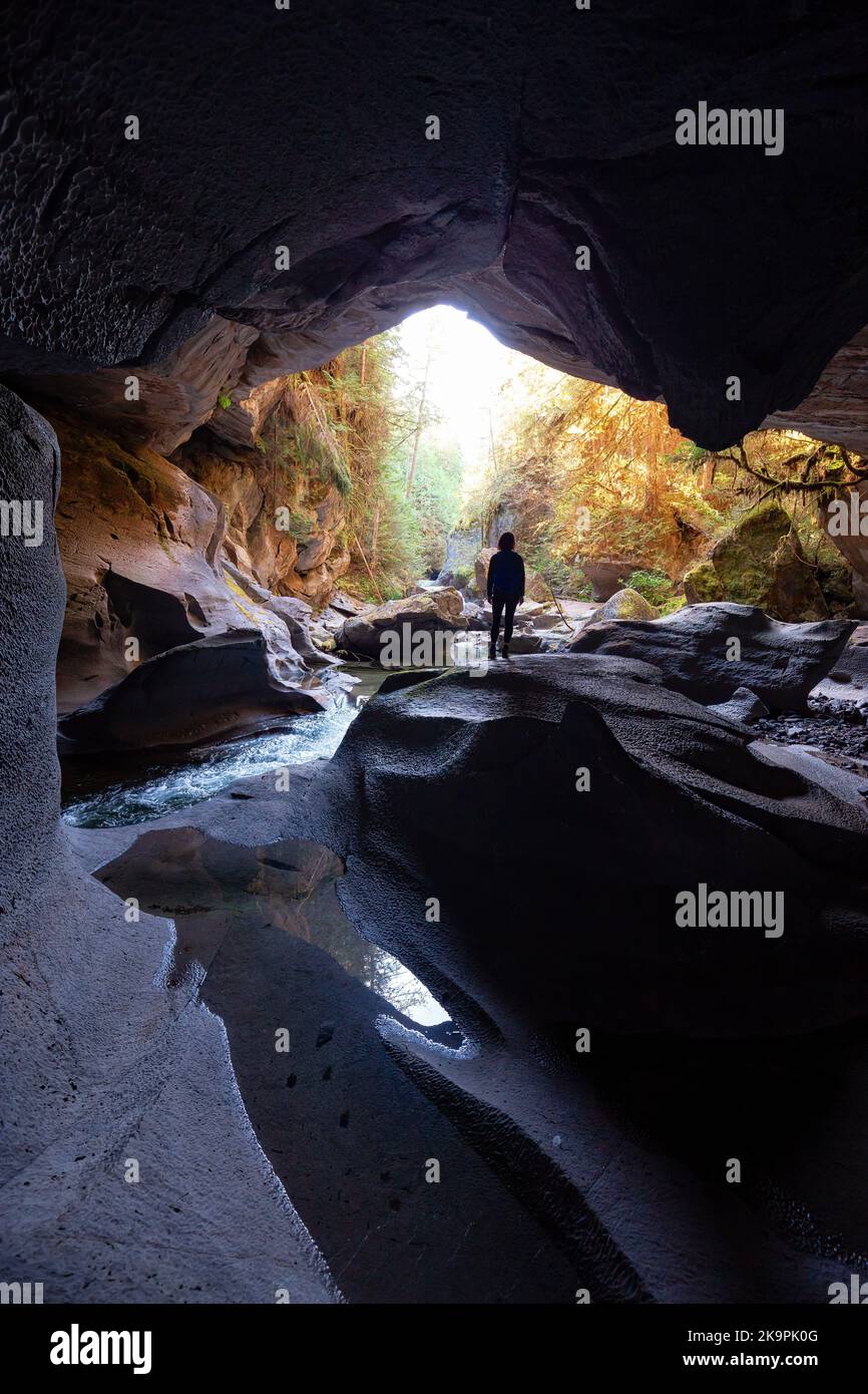 Adventurous woman standing inside a cave. Adventure Travel. Little ...