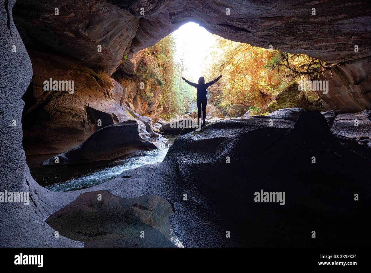 Adventurous woman standing inside a cave. Adventure Travel. Little ...
